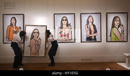 Art handlers hang an image in a series called Ruth Smoking by Julian ...