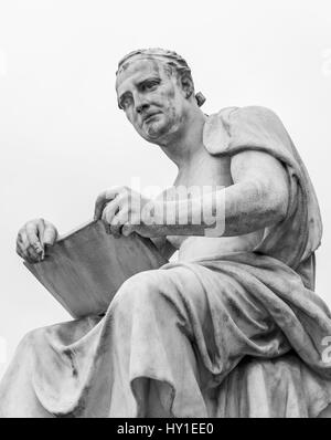 A marble statue of a robed Greek philosopher reaching out with an open ...