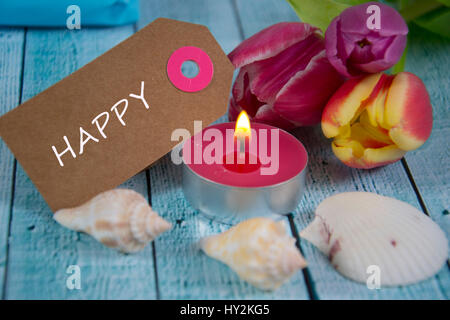 Inscription "BE HAPPY" written on paper with flowers and petals on ...