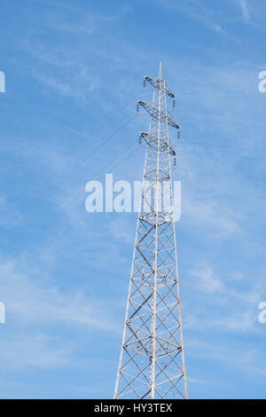 White painted electricity pylon with blue sky and white clouds in ...