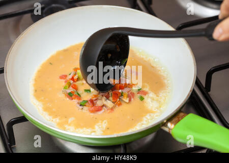 Omelet preparation : Pouring the omelet mix onto a pan Stock Photo - Alamy
