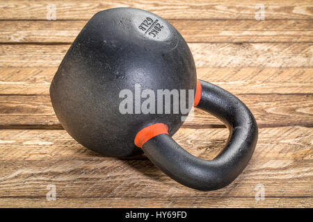 iron kettlebell on a rustic wood background against grunge wall with a ...