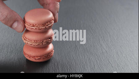 man hand stacking pink strawberry macarons on slate board, 4k photo ...