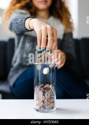 Woman Dropping Coins Stock Photo - Alamy