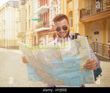 Young hipster man with map Stock Photo - Alamy