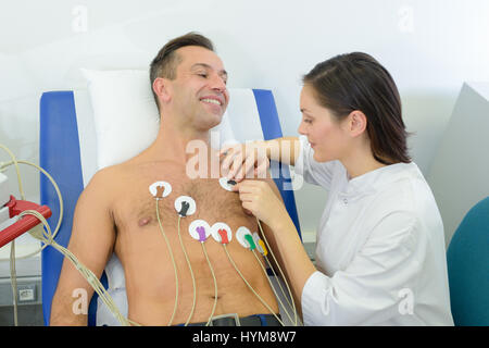 Nurse attaching heart monitor pads to patient Stock Photo - Alamy