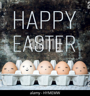 Five Easter eggs with funny faces and gray crocheted hats with bunny ears on a gray background ...