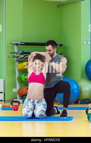 Young woman working out with personal trainer at gym Stock Photo - Alamy