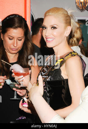 Singer Gwen Stefani drinking a colorful mixed drink at the Gwen Stefani ...
