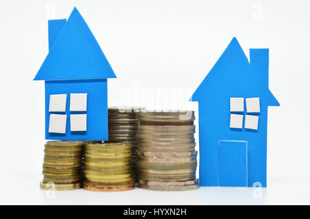 Blue paper house model and stacks of coins Stock Photo - Alamy