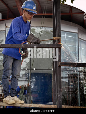 A man using an oxy acetylene torch in work to demolish a buiding Stock ...