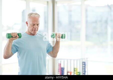 Senior man using weights Stock Photo - Alamy