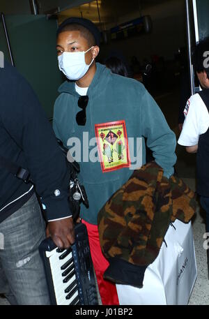 Pharrell Williams wears a surgical face mask as he arrives at Los ...