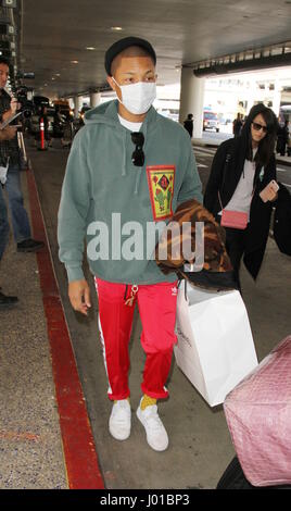 Pharrell Williams wears a surgical face mask as he arrives at Los ...