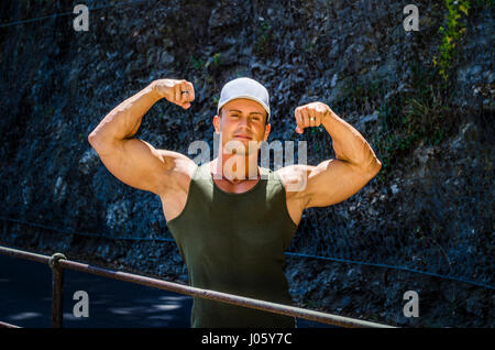 Young bodybuilder doing double biceps pose Stock Photo - Alamy