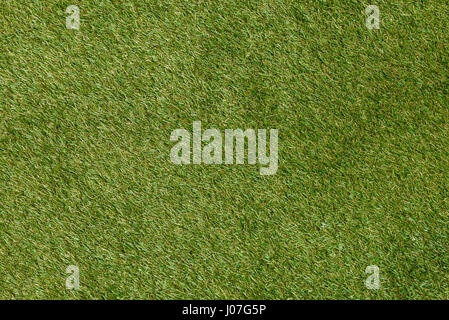 Close-up of artificial green grass turf with dense plastic fibers and ...