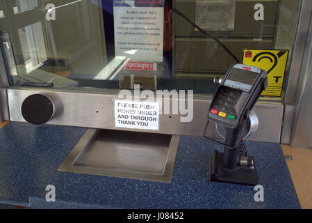 Woman buying rail ticket from a ticket vending machine at a station, UK ...