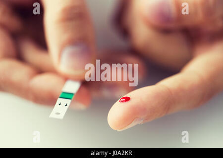 Home blood test. Finger stick with disposable lancet. Blood droplet ...