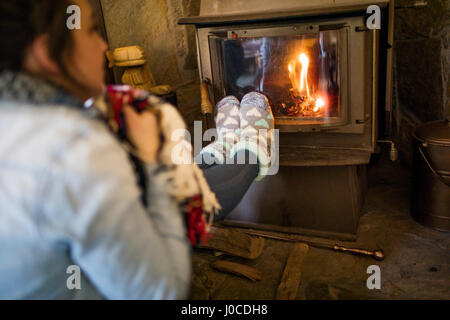 Woman warming feet in front of a cosy fire at Christmas time Stock ...