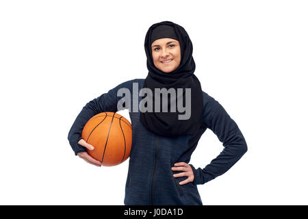Woman in hijab with basketball ball sitting on basketball court Stock ...