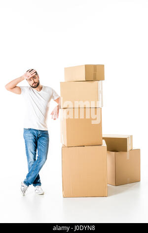 Tired young man carrying stack of boxes. Exhausted male carrier with ...