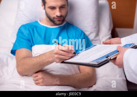 patient in hospital bed signing consent form Stock Photo - Alamy