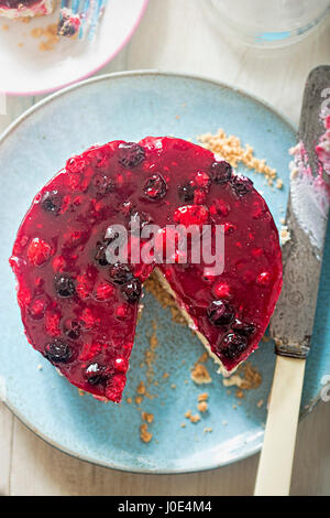 A cheesecake with berries and red jelly on a black background Stock ...