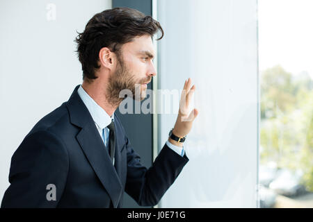 businessman in suit standind next to an office building window Stock ...