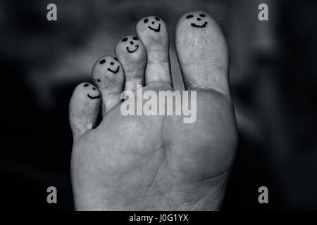 all ten toes of feet with smiley faces drawn with black pen Stock Photo ...
