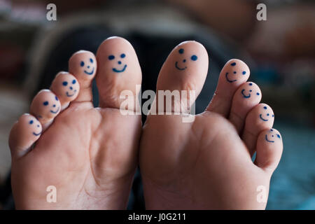 all ten toes of feet with smiley faces drawn with black pen Stock Photo ...