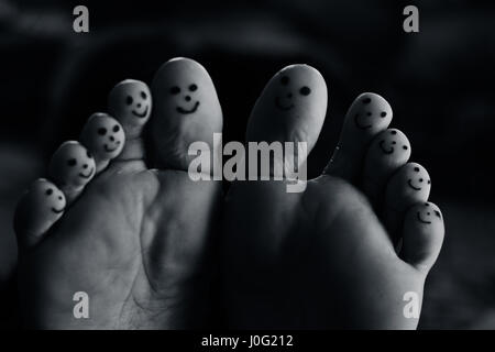 all ten toes of feet with smiley faces drawn with black pen Stock Photo ...