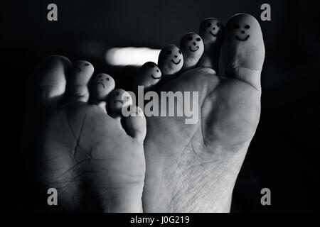 all ten toes of feet with smiley faces drawn with black pen Stock Photo ...