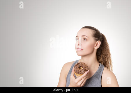 fitness woman eating a cheeky donut Stock Photo - Alamy