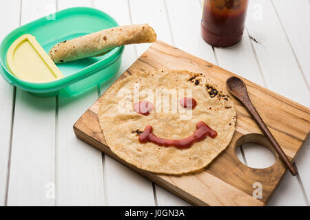 ketchup or fruit jelly/jam smile emoticon over indian bread / chapati ...