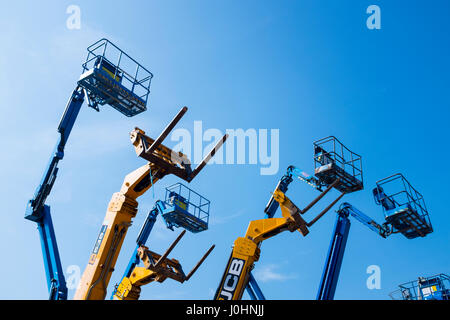Cherry pickers in upright position with blue sky Stock Photo - Alamy