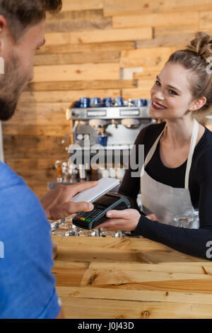 Smiling woman holding credit card and using laptop near coffee and ...