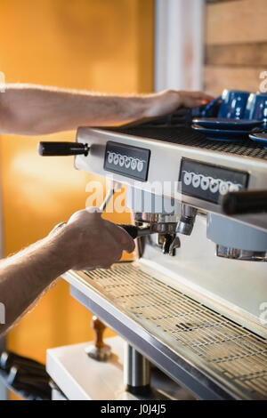 Waiter preparing coffee from coffee machine Stock Photo - Alamy