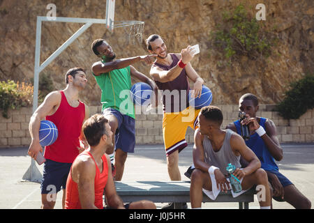Basketball players taking a selfie in basketball court outdoors Stock ...