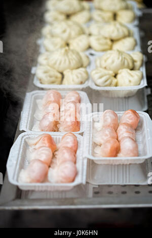 Chinese food stall with bamboo container of steamed buns, plates of ...