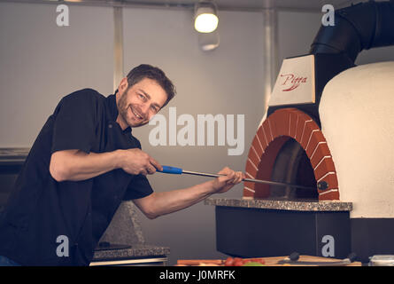 Chef baking pizza in the italian pizzeria Stock Photo - Alamy