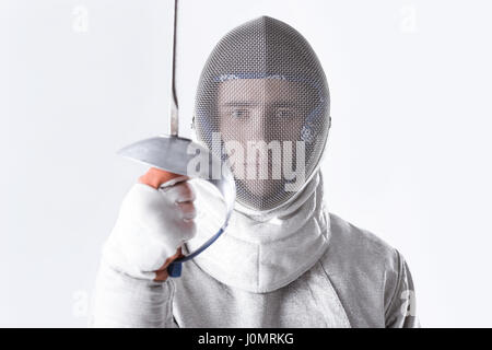 portrait of fencer in uniform holding rapier in hand on white Stock ...
