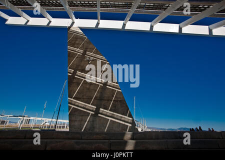 Light and shadow splay diagonal lines across the concrete column of the ...