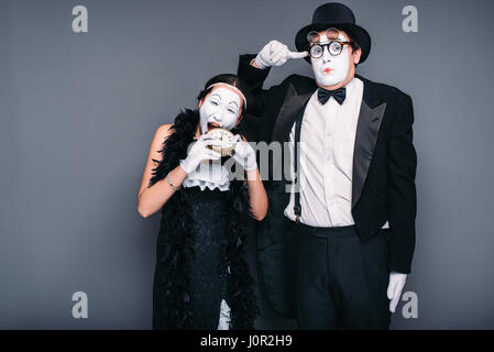 Pantomime actors performing with alarm clock. Comedy artist and actress ...
