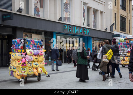 Primark on Queen Street, Cardiff. Vendors in the foreground are selling ...