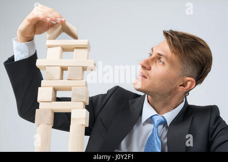 Businessman making tower Stock Photo - Alamy