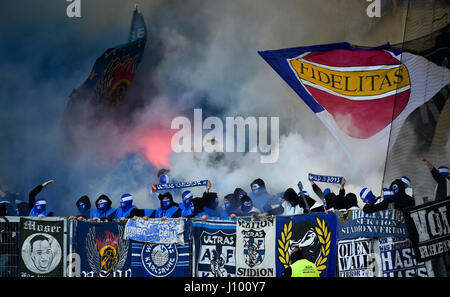 Radical fans at soccer match, hooded hooligans with Bengal light ...