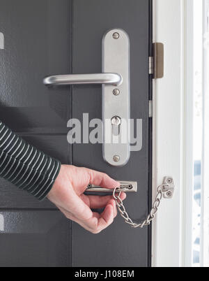 Door chain on a grey door, security measures Stock Photo - Alamy