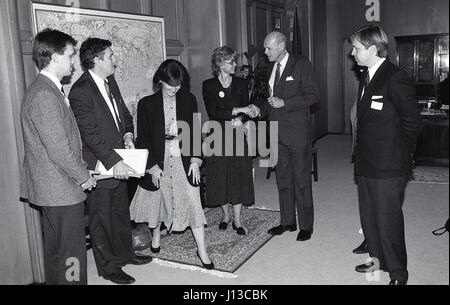 A group of military or organizational personnel converse in an office ...