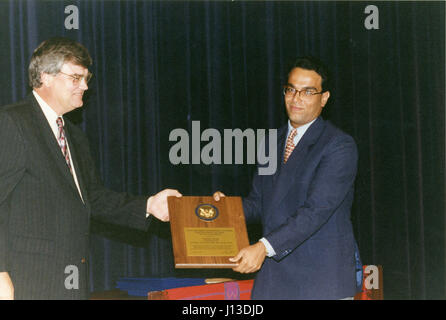 An individual receives an award during a USAID honors ceremony ...