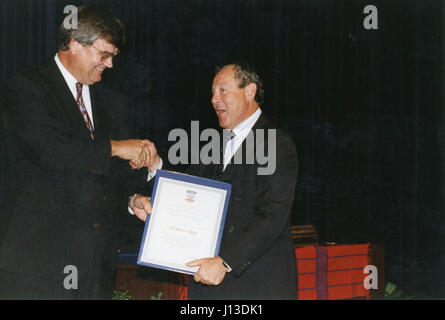 An individual receives an award during a USAID honors ceremony ...